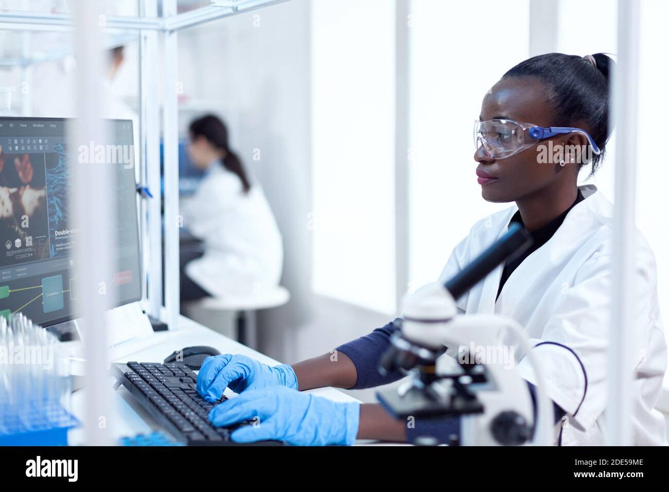 Professional african medical worker typing information about virus ...