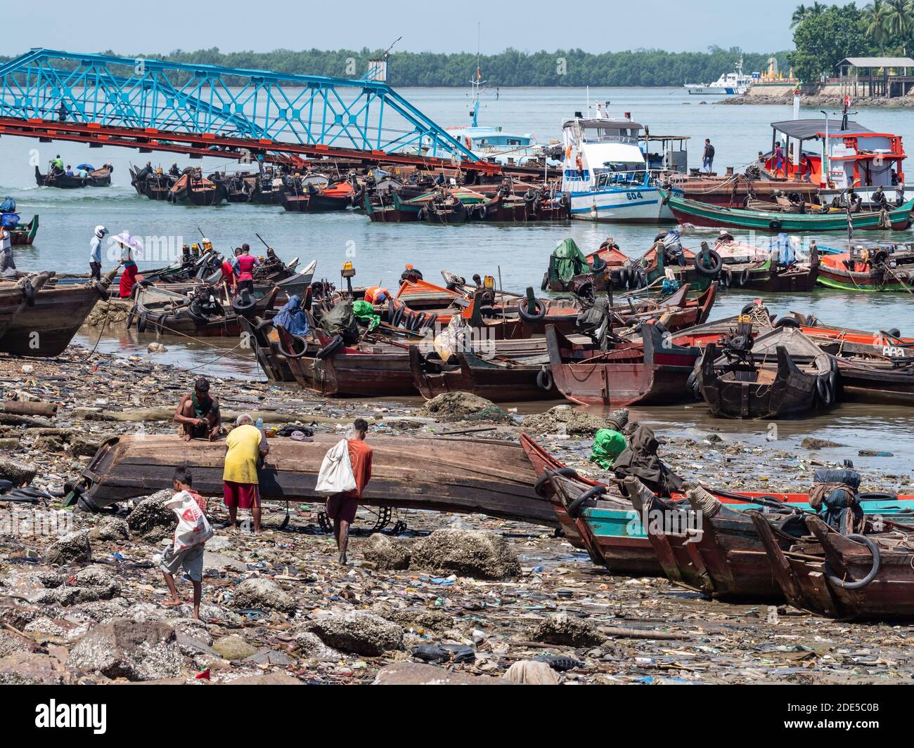Boats around the crowded ferry pier in Myeik, at low tide on the strait ...