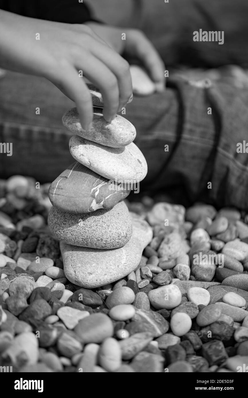 Boy building a stone pyramid, Montenegro. black and white photo Stock ...