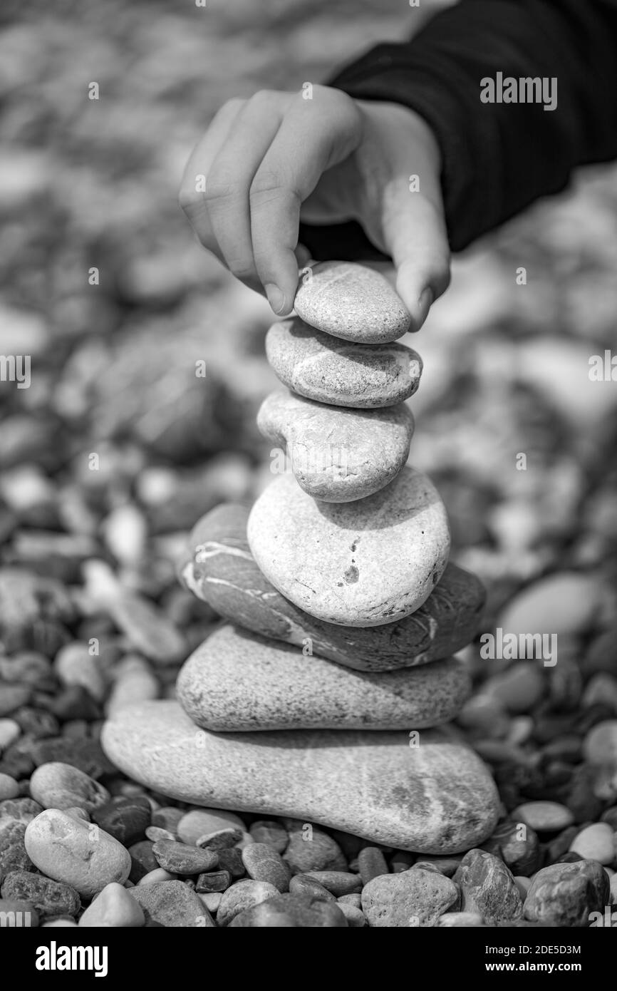 Boy building a stone pyramid, Montenegro. black and white photo Stock ...