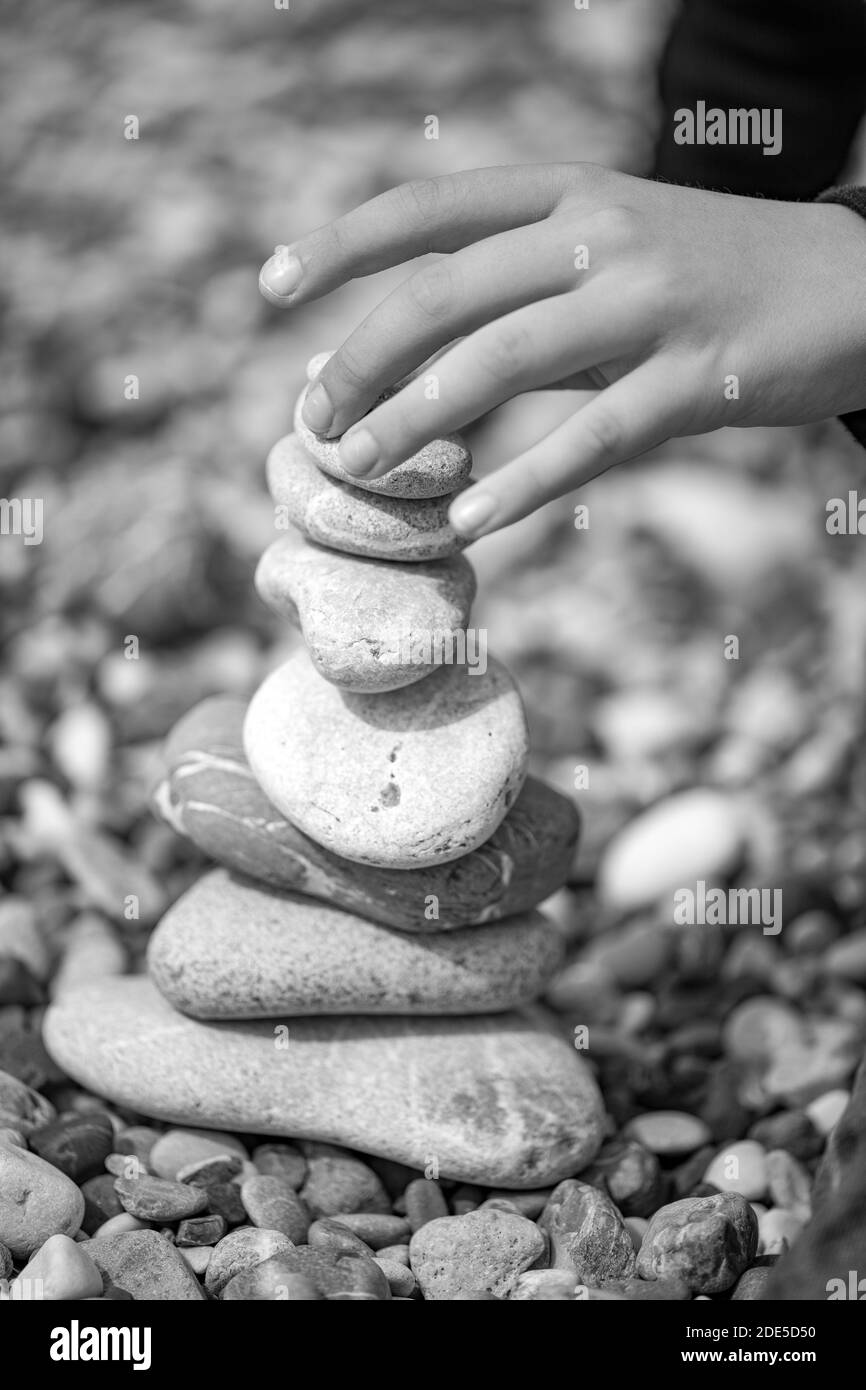 Boy building a stone pyramid, Montenegro. black and white photo Stock ...