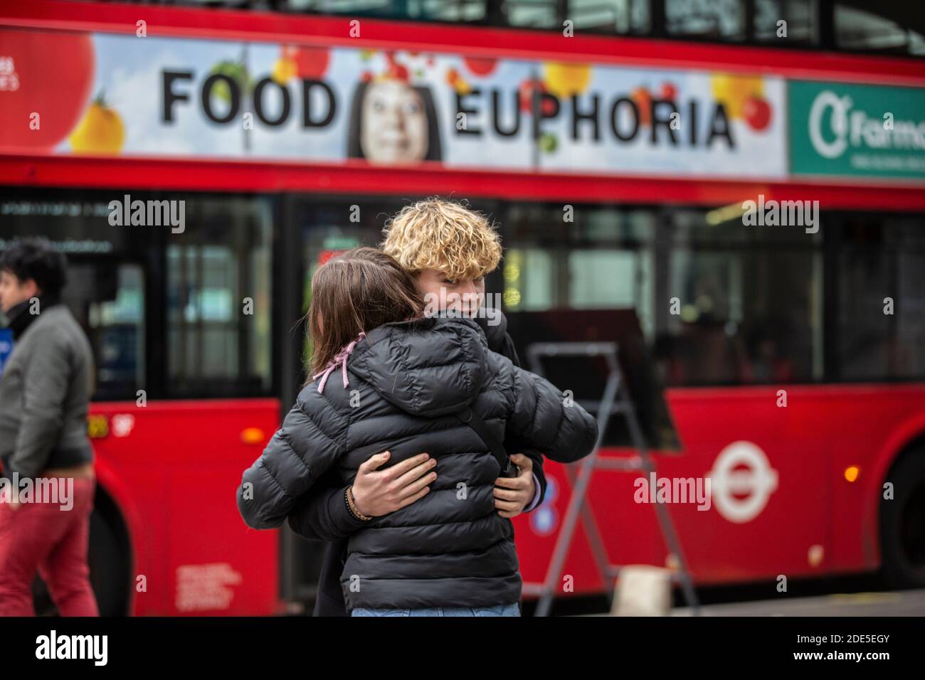 A couple of teenagers hug in the street, Oxford Circus, London, England ...