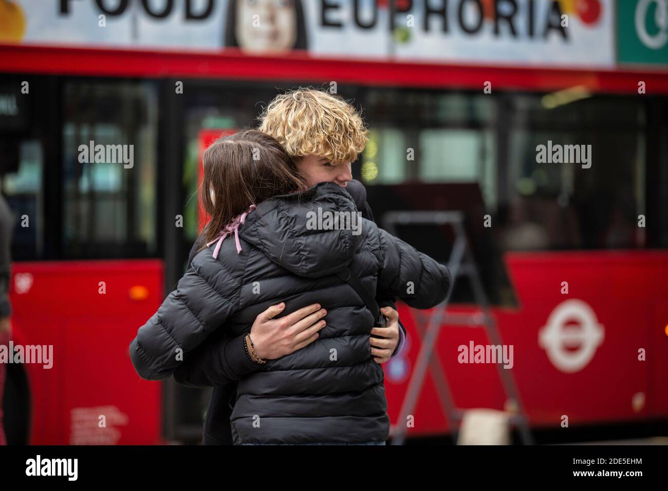A couple of teenagers hug in the street, Oxford Circus, London, England ...