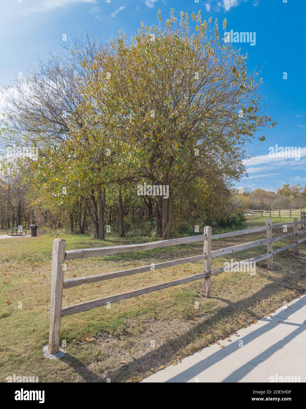 Scenic park entrance with rustic wooden fence and pathway with colorful ...