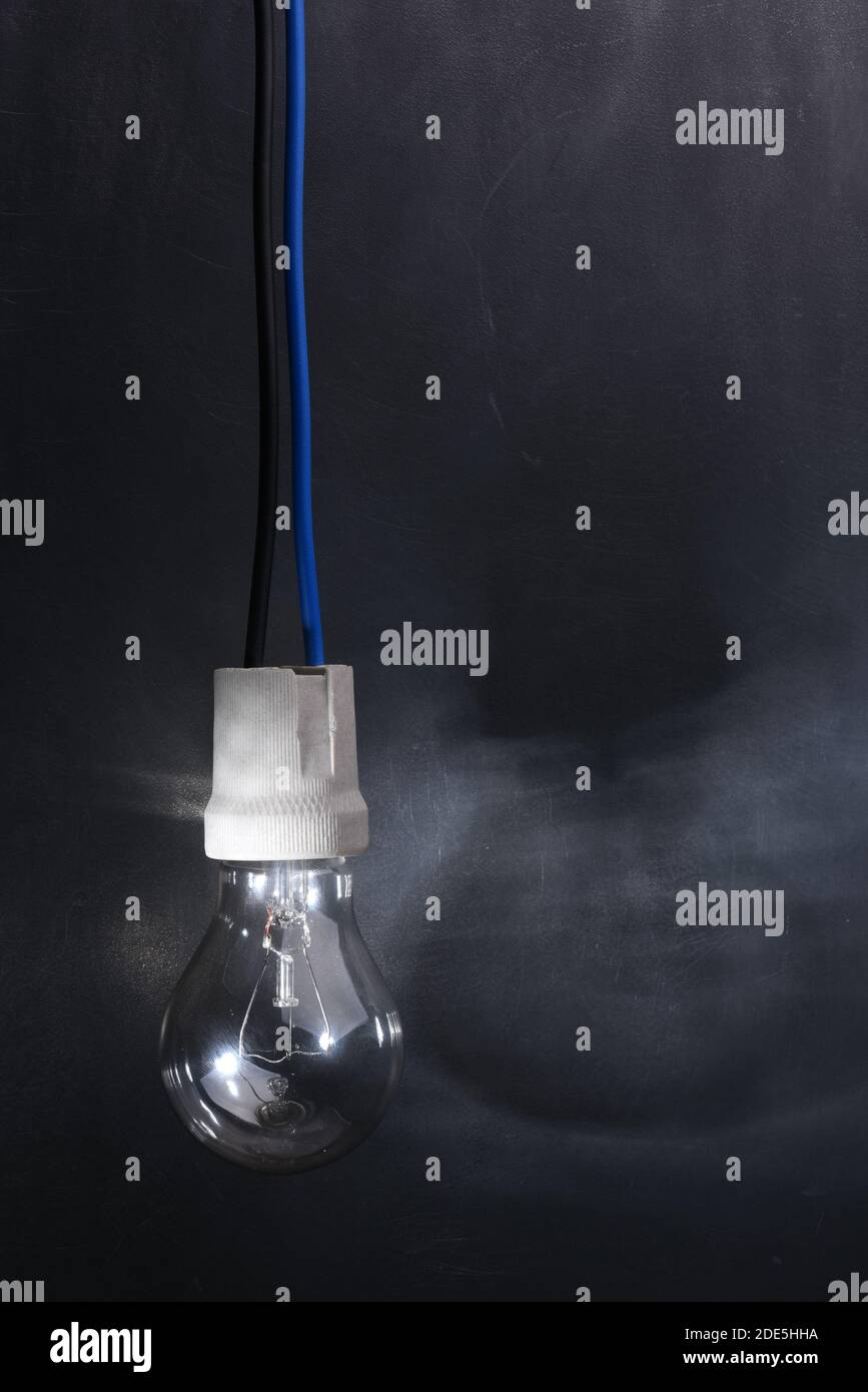 Light bulb on electric cable with shadow in dark room Stock Photo - Alamy