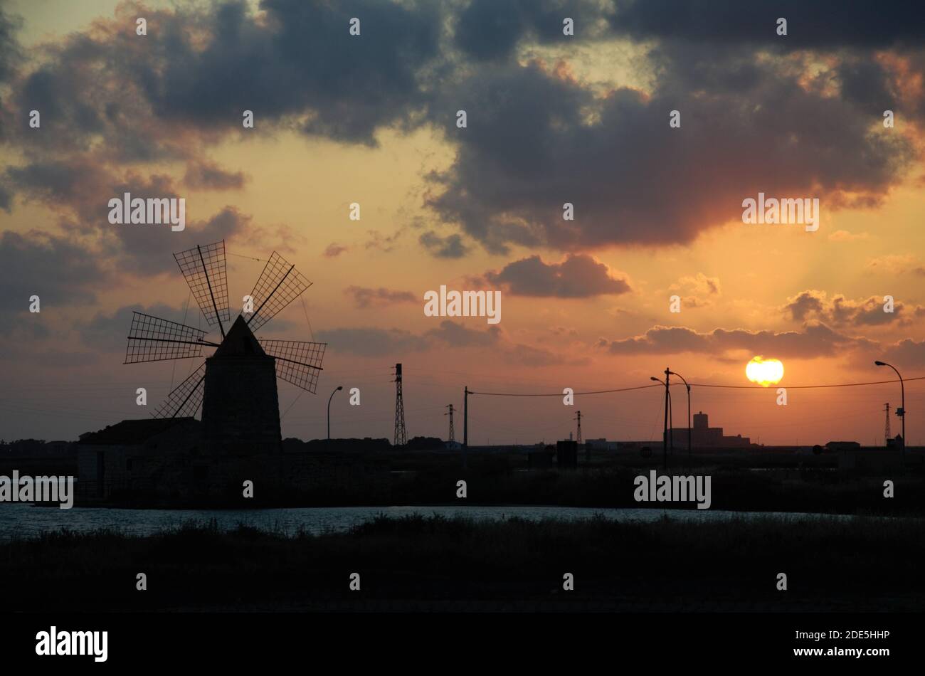 Silhouette of windmill and lamp post outside Trapani, Sicily, Italy ...