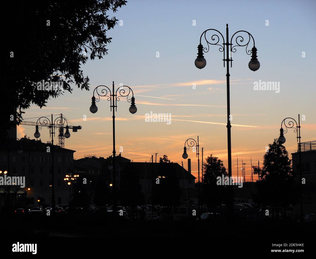 Silhouette of streetlights in the Italian city of Trieste during sunset ...