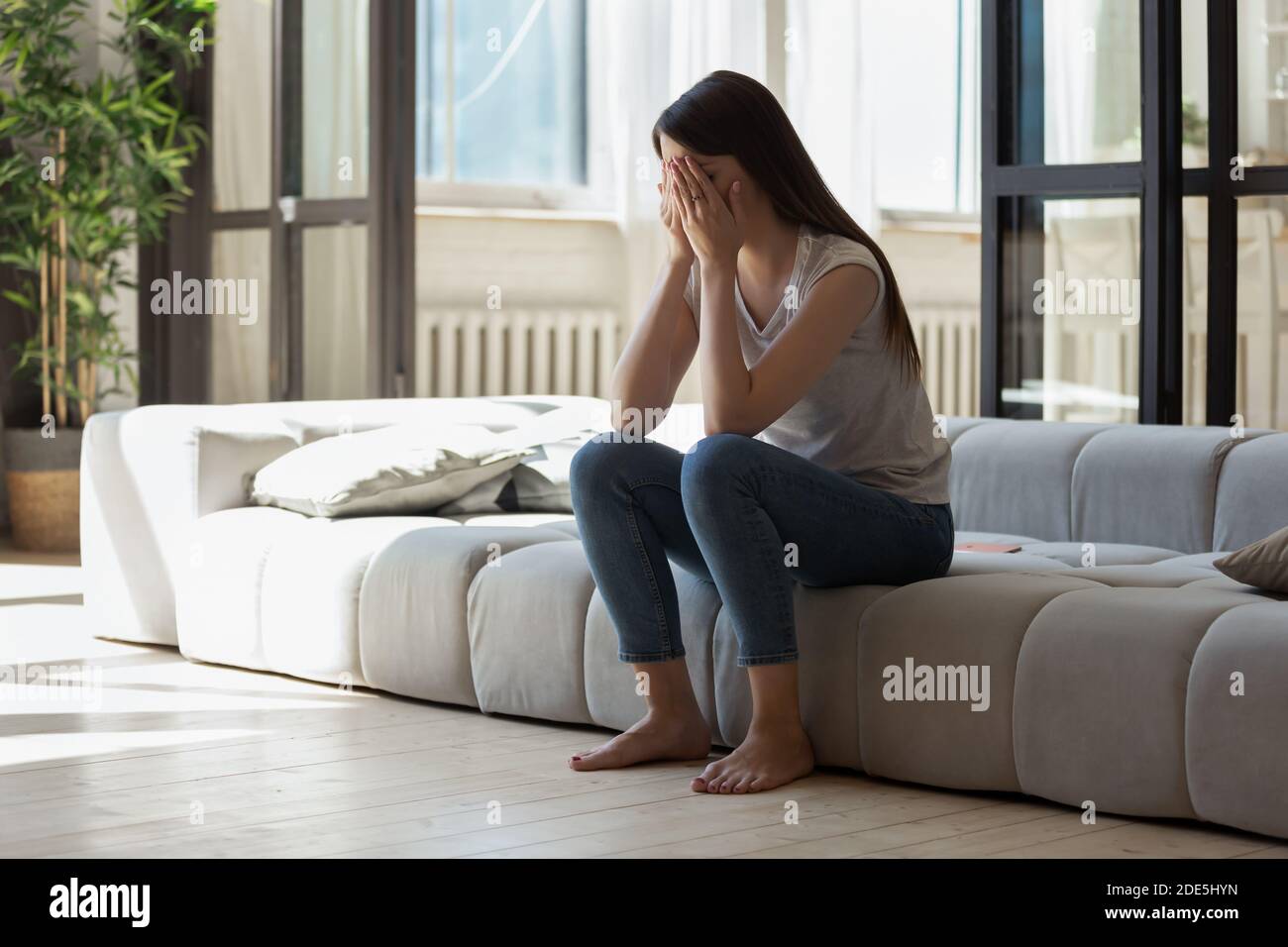 Unhappy young woman covering face with hands, crying alone Stock Photo ...