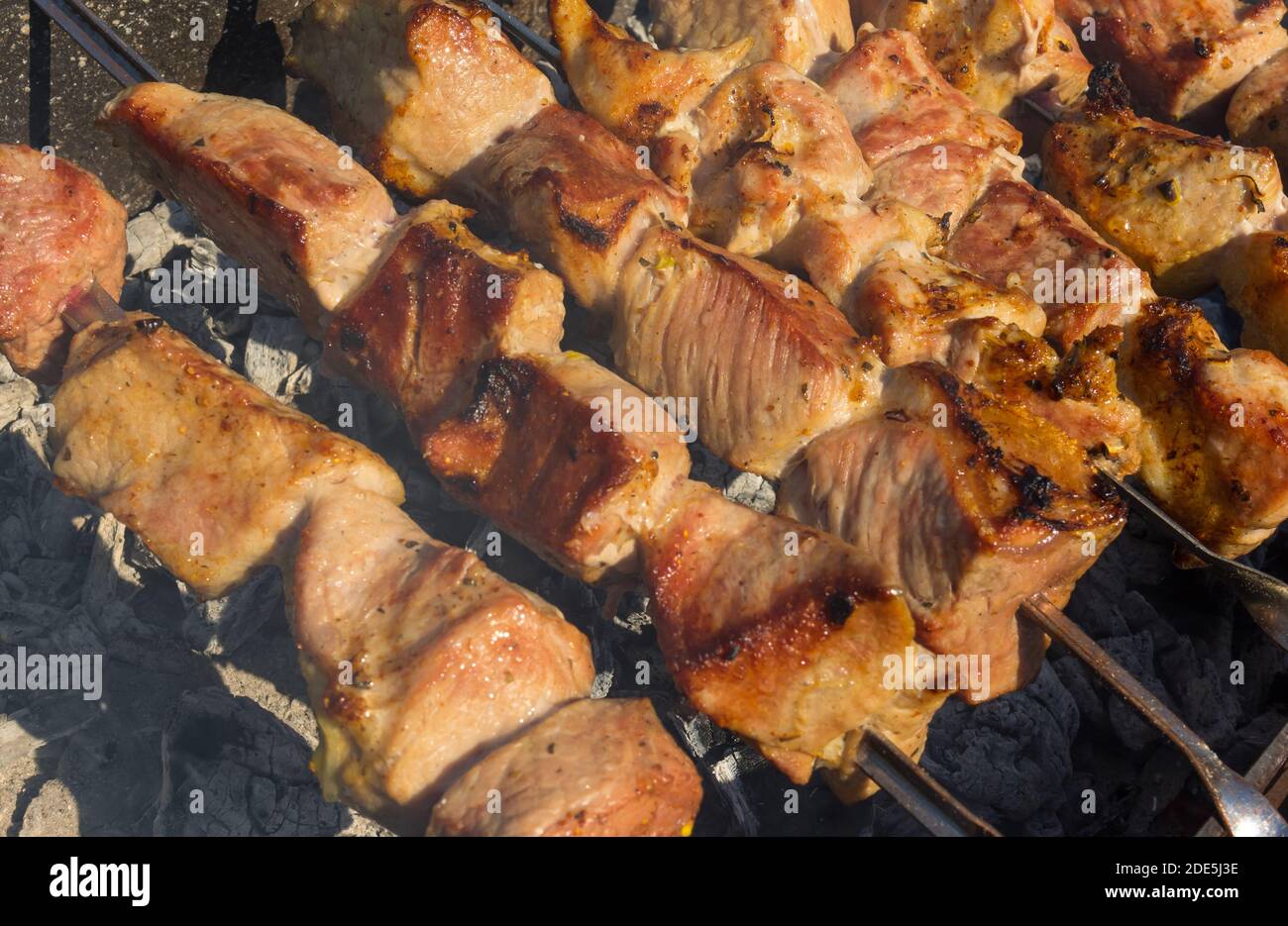 Juicy pork meat on skewers cooking outdoor on smouldering carbons Stock ...