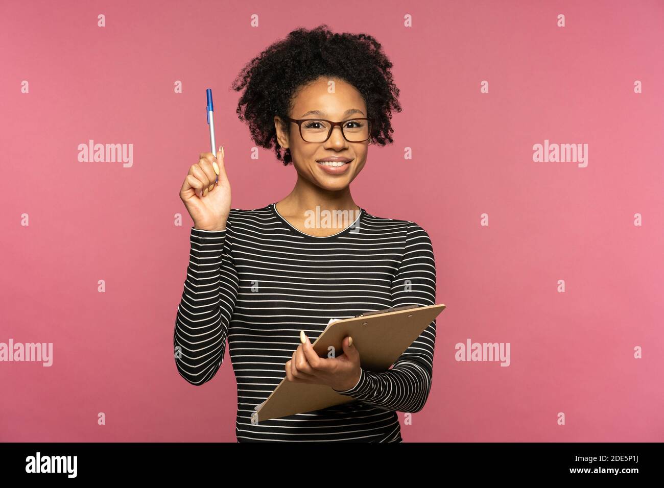 Young happy Afro-American teacher woman isolated on pink studio wall ...