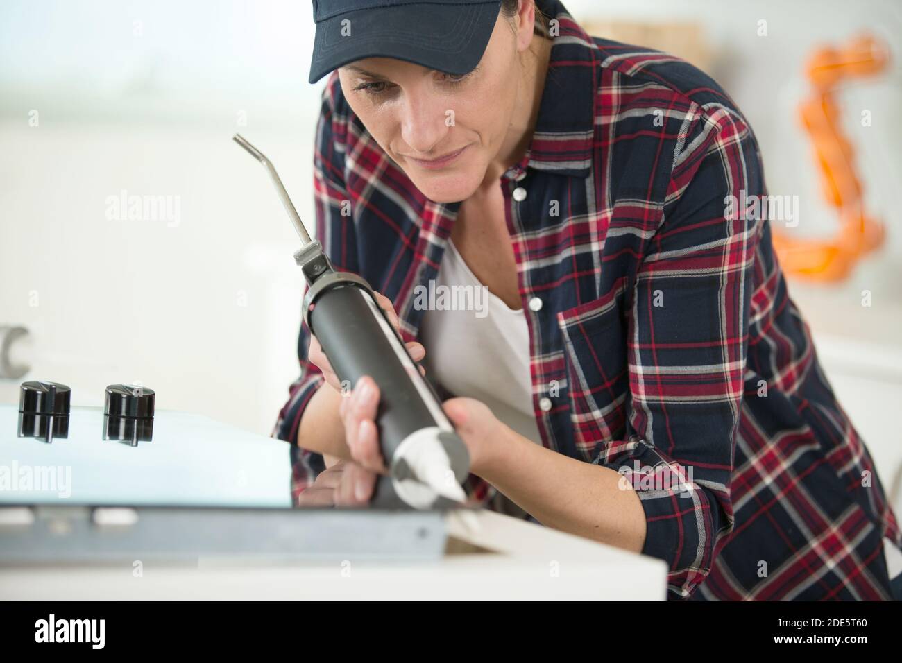 a woman is repairing kitchen Stock Photo - Alamy