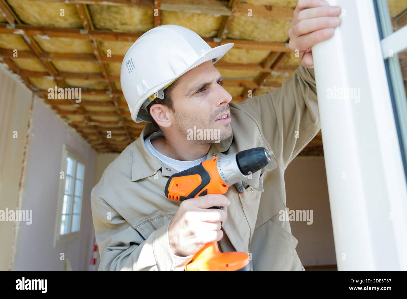 window fitter holding a cordless drill Stock Photo - Alamy