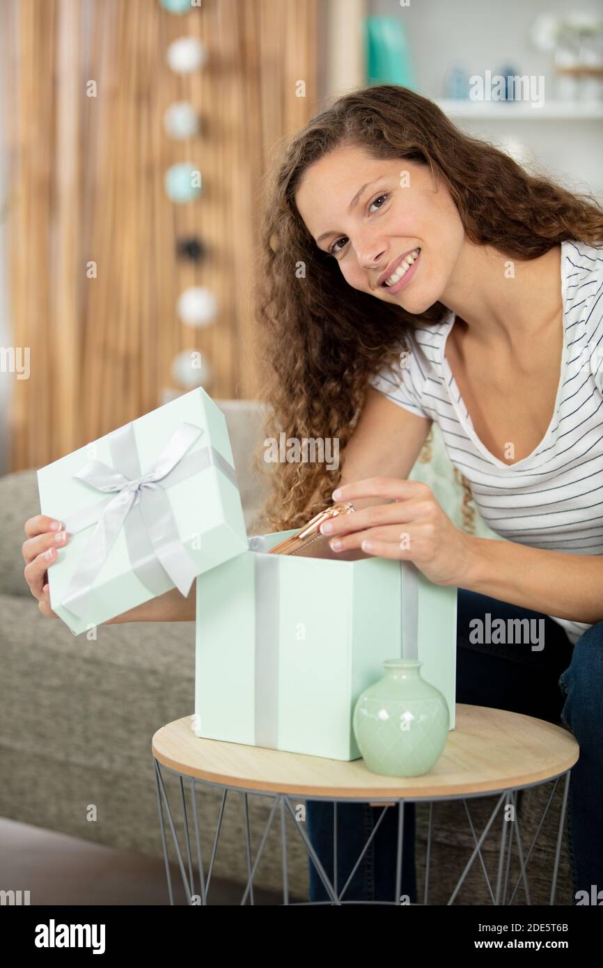 picture showing woman opening present on sofa Stock Photo - Alamy