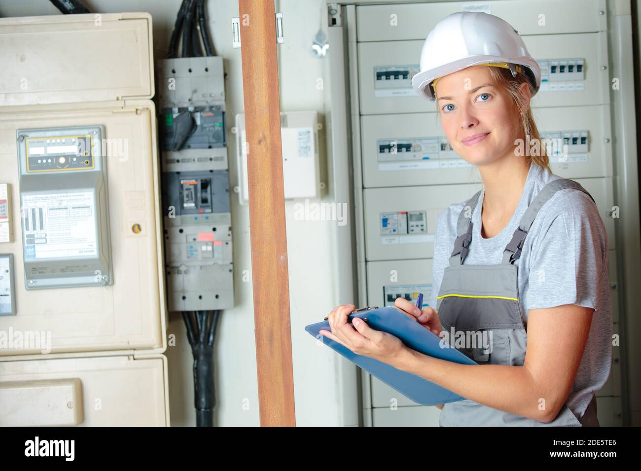 female electrician with clipboard reading a meter Stock Photo - Alamy