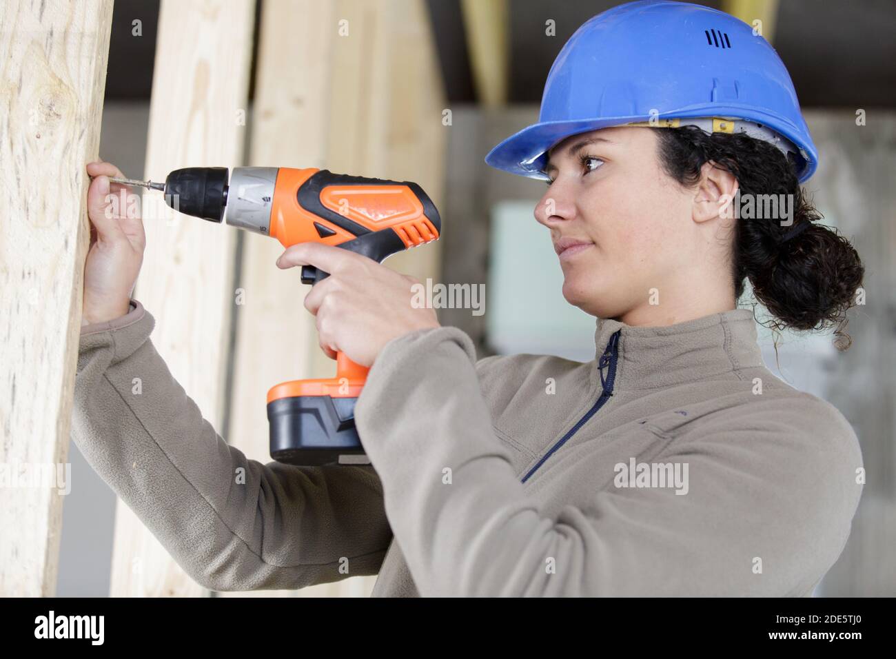 side view of female builder using cordless drill Stock Photo - Alamy