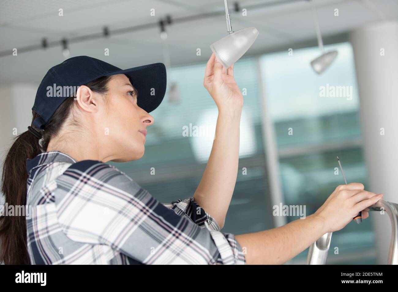 a woman is changing lightbulb Stock Photo - Alamy