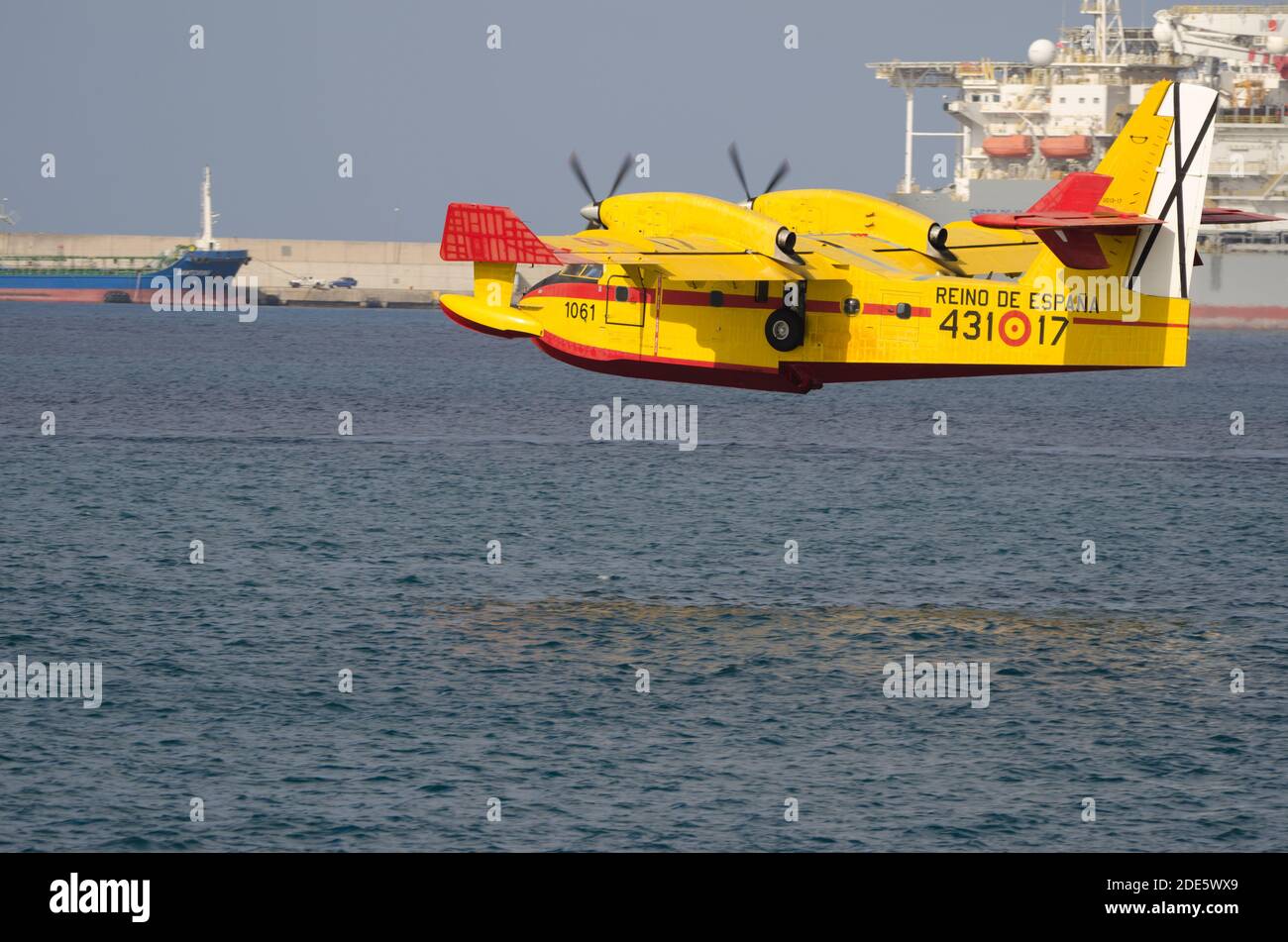 Fire-fighting plane collecting sea water to extinguish a forest fire ...