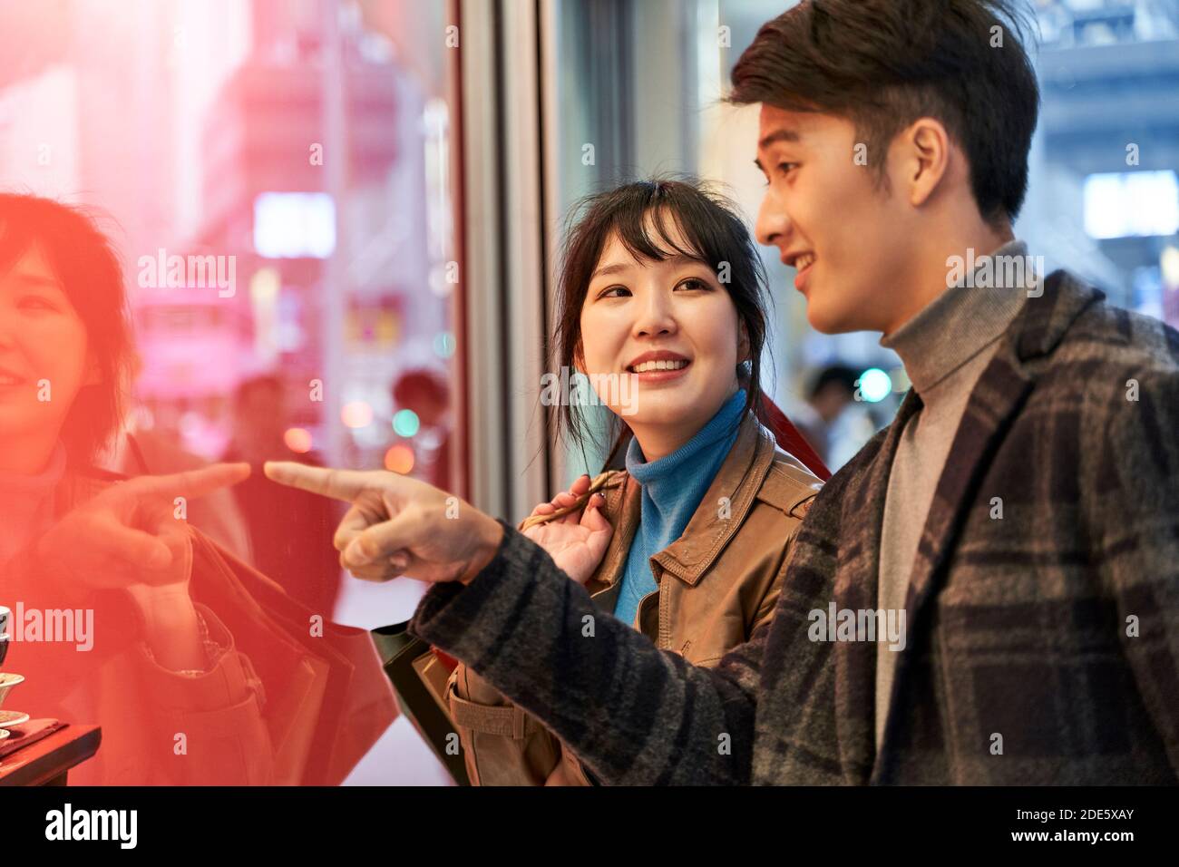 loving young asian couple looking at shop window and talking happy and ...