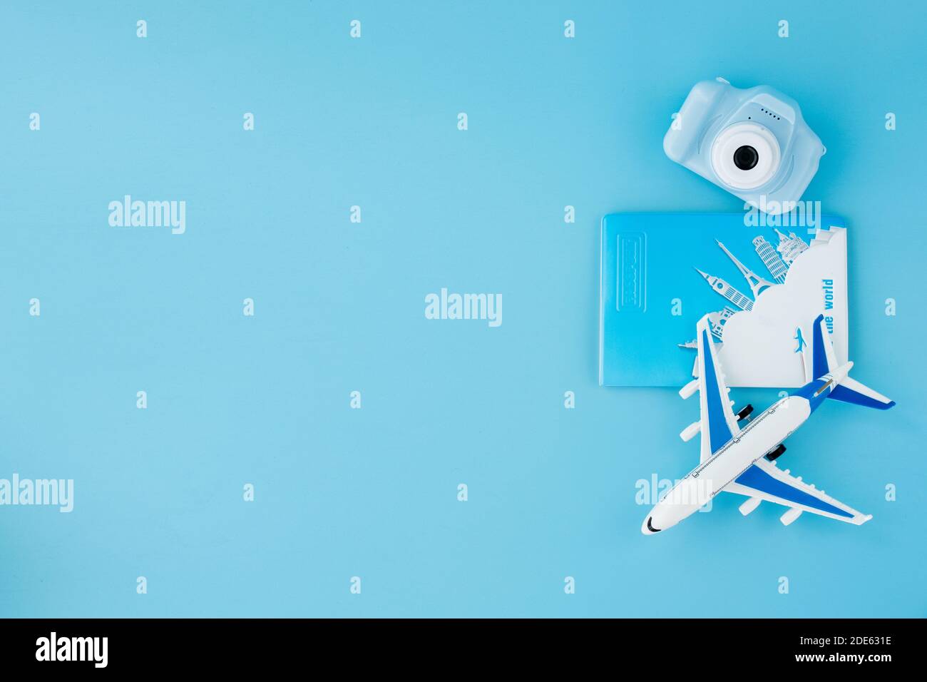 Camera, passport and airplane on light blue background.Summer or ...