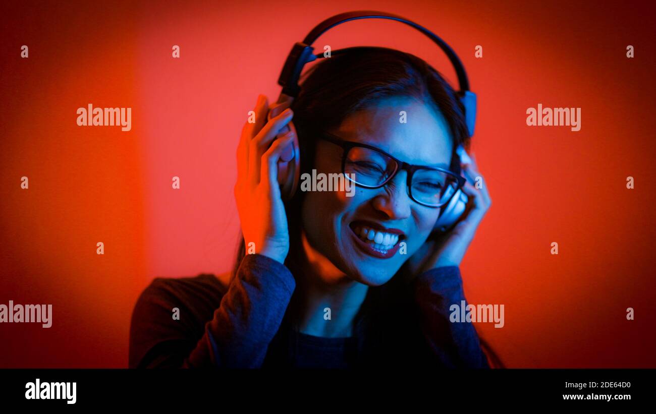 Young Asian woman listens to music - strong colorful shot Stock Photo ...