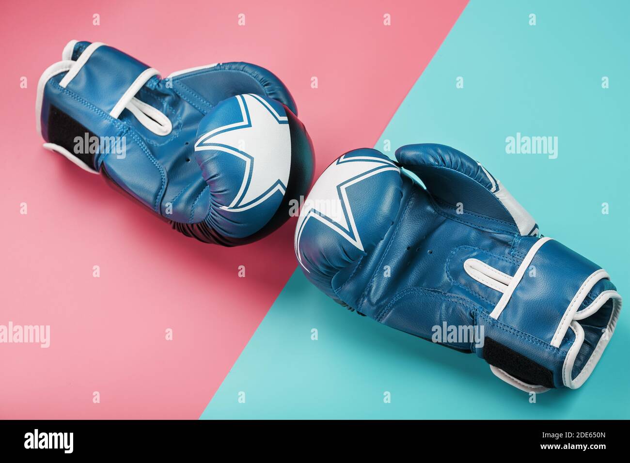 Boxing blue gloves on a pink and blue background diagonally. Close up ...