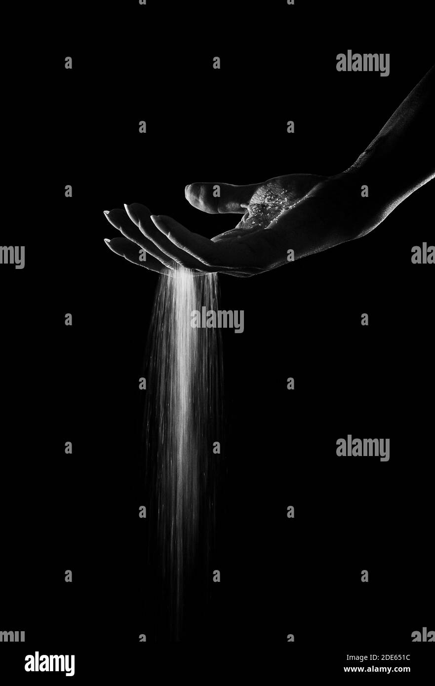 Beautiful Woman's Hand in Rim Light with sand slipping through fingers ...