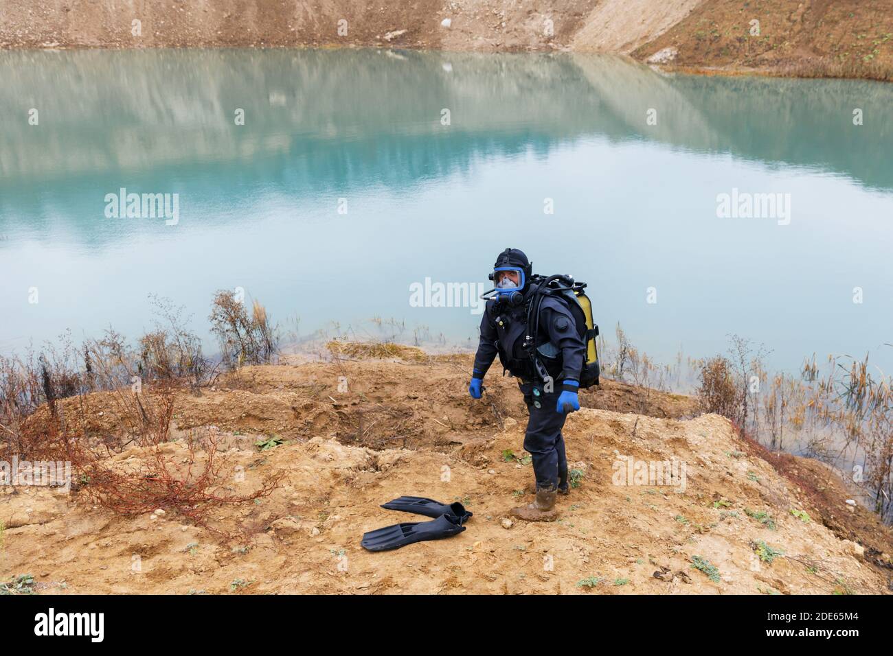 A lifeguard in a wetsuit is preparing to dive into the pond. Search at ...