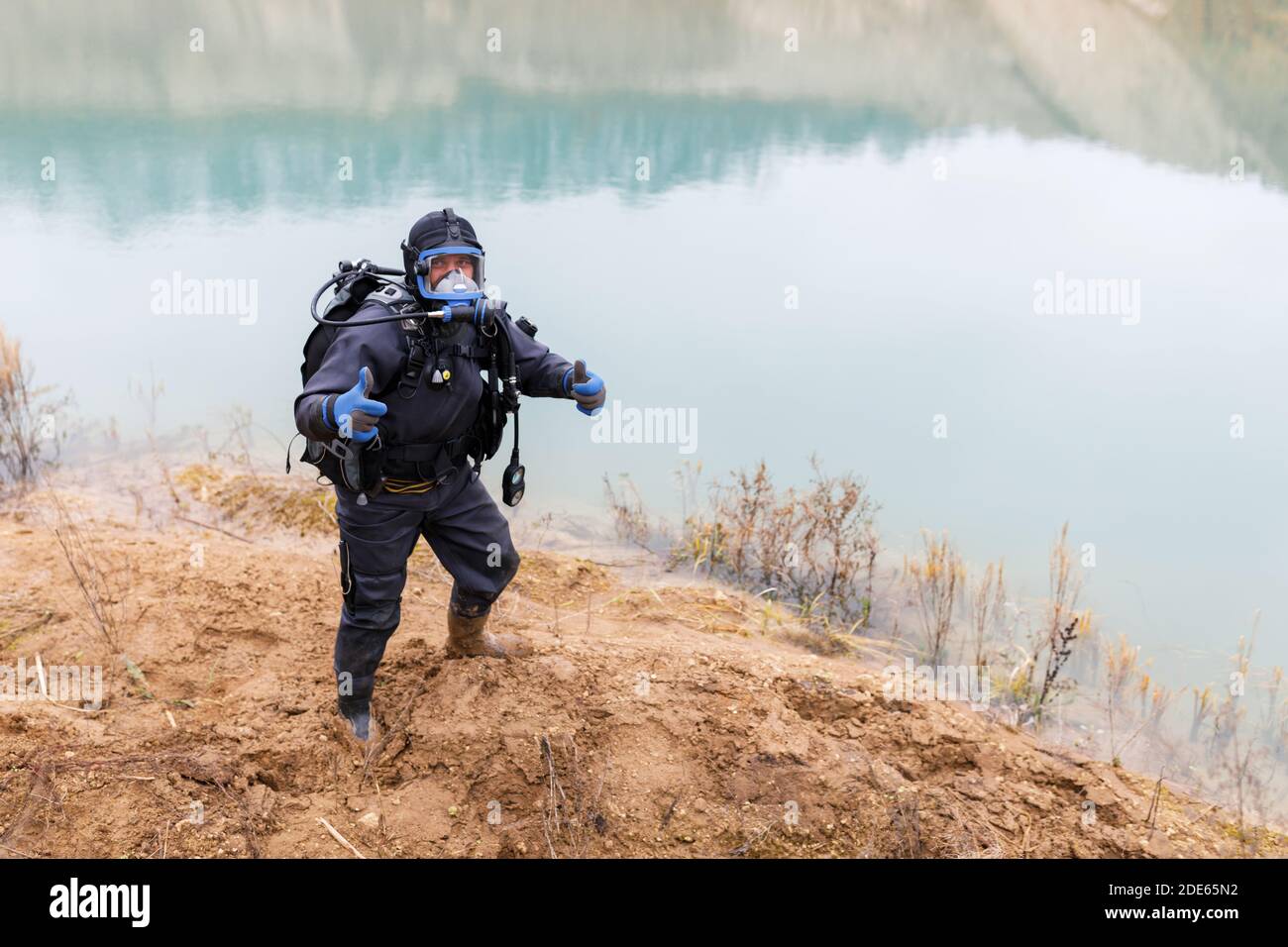 A lifeguard in a wetsuit is preparing to dive into the pond. Search at ...