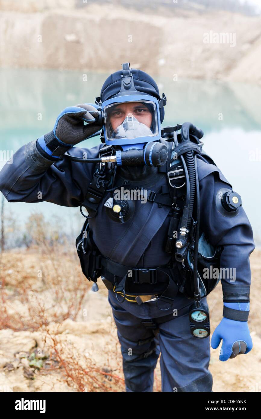 A lifeguard in a wetsuit is preparing to dive into the pond. Search at ...