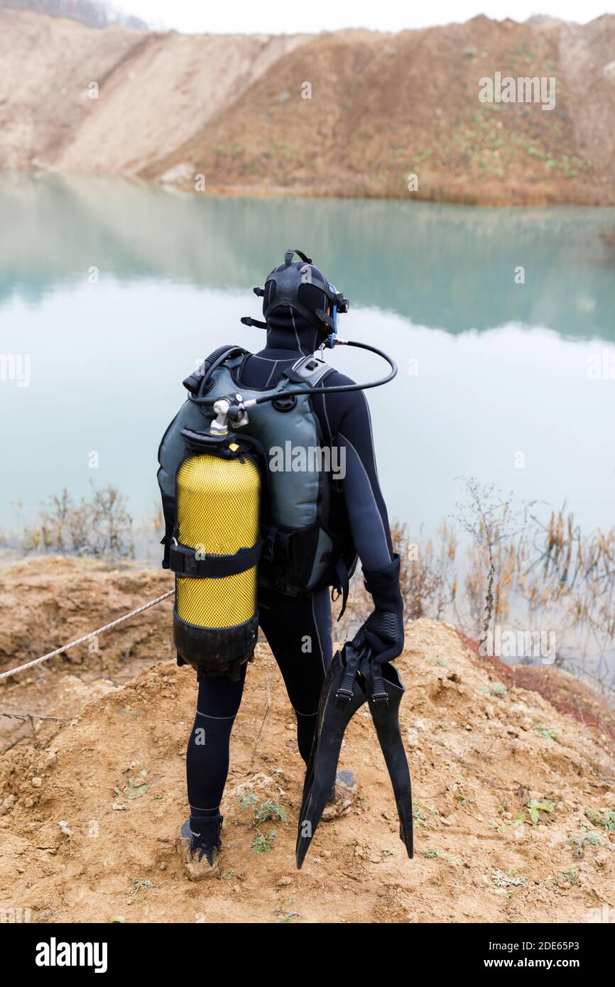A lifeguard in a wetsuit is preparing to dive into the pond. Search at ...