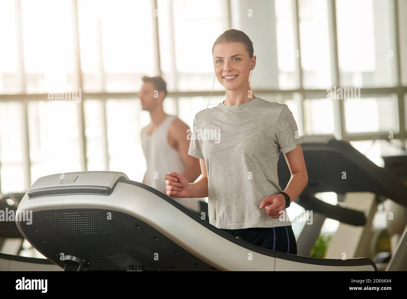 Fit young woman running on treadmill Stock Photo - Alamy