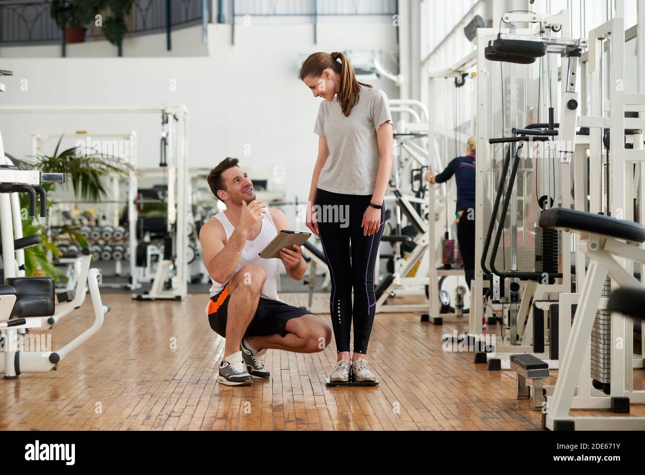 Personal trainer and woman checking her progress Stock Photo - Alamy