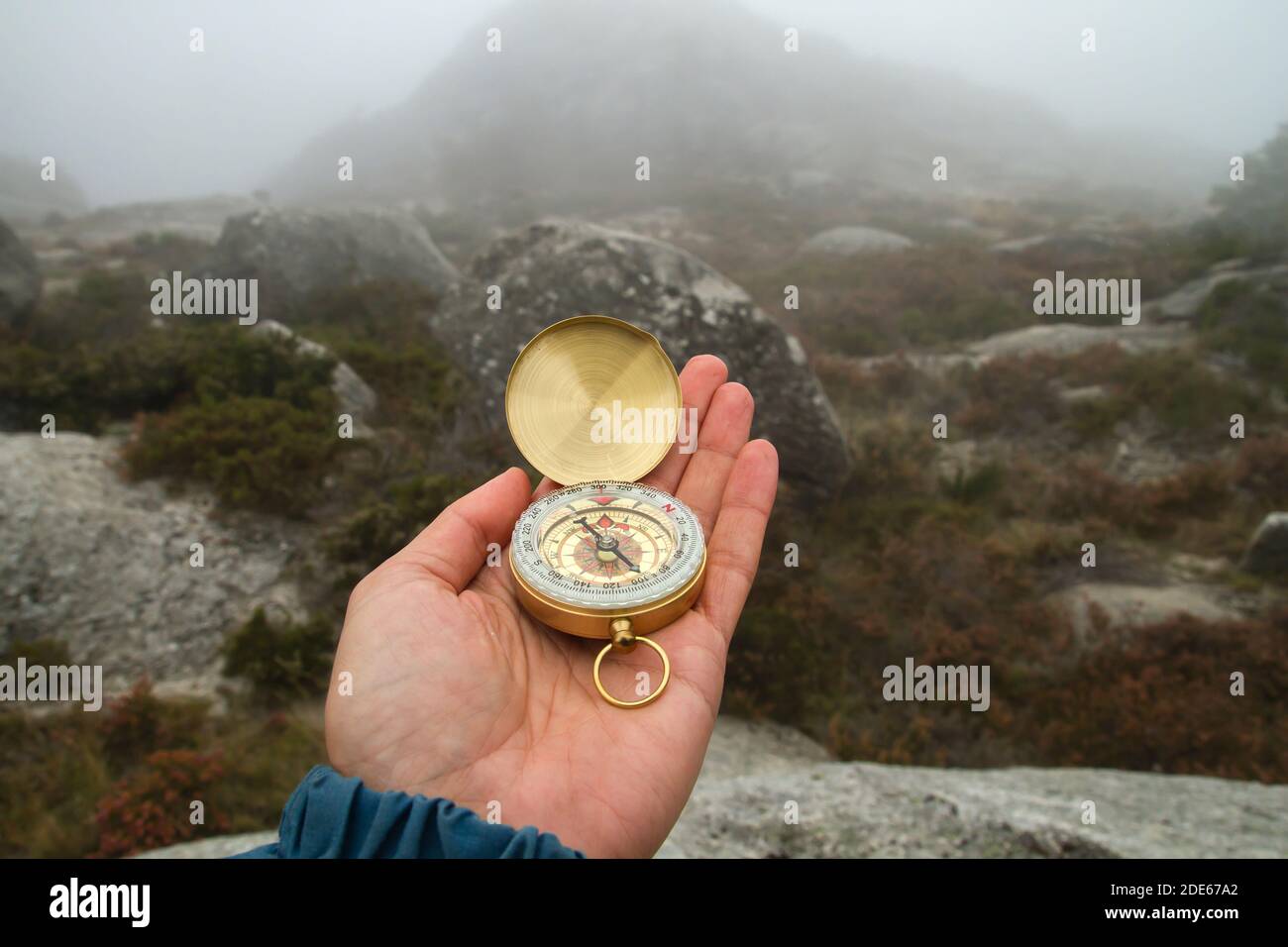 Explorer orienteering with compass in a foggy day Stock Photo - Alamy