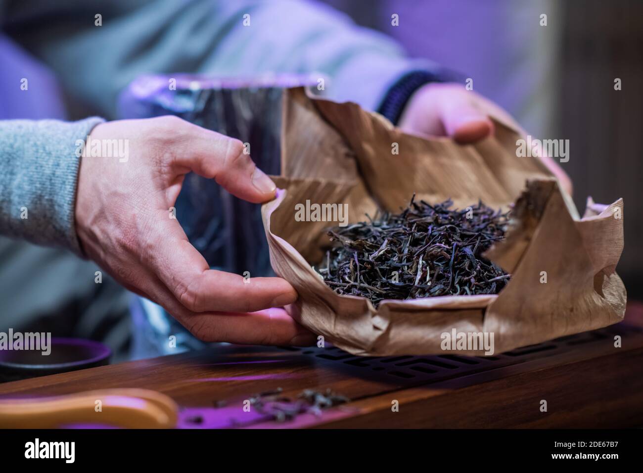 Black chinese tea leaves, dried and spread out on a paper wrapper close ...