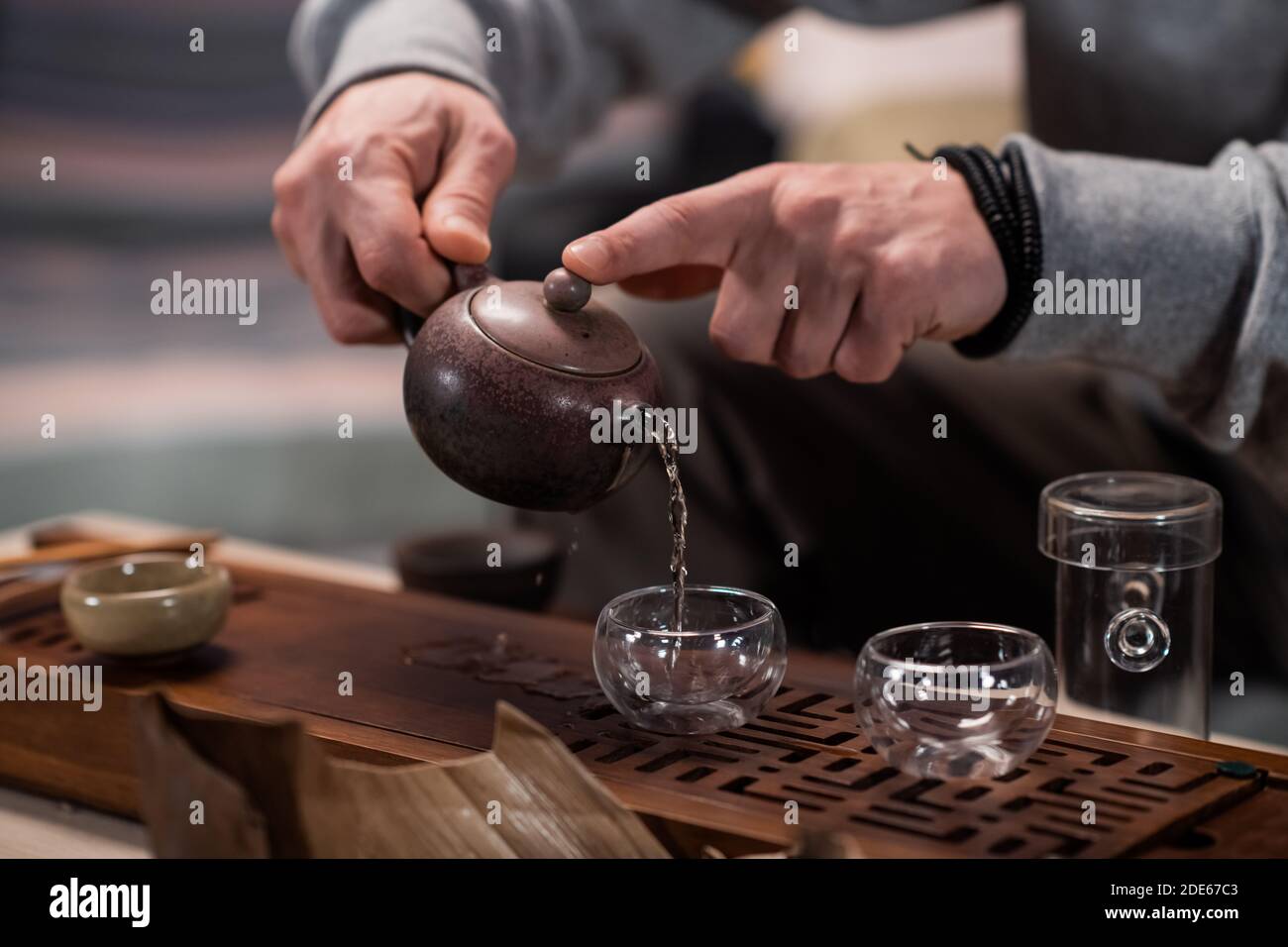 Close-up of a traditional ceramic teapot with hot aromatic tea filling ...