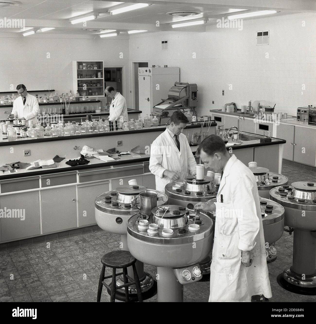 1960s, historical, male research scientists wearing white coats working ...