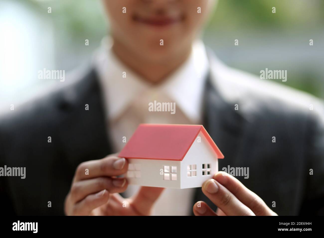 Businessman holding model house. Architecture, building, construction ...