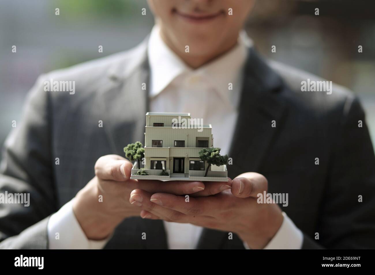 Businessman holding model house. Architecture, building, construction ...