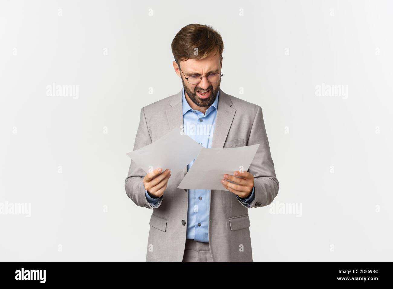 Portrait of angry and confused businessman in grey suit, looking at ...