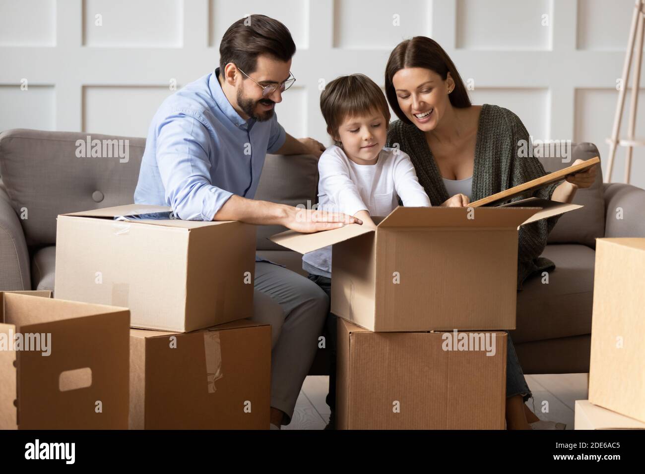 Happy family with small kid unpack boxes on moving day Stock Photo - Alamy