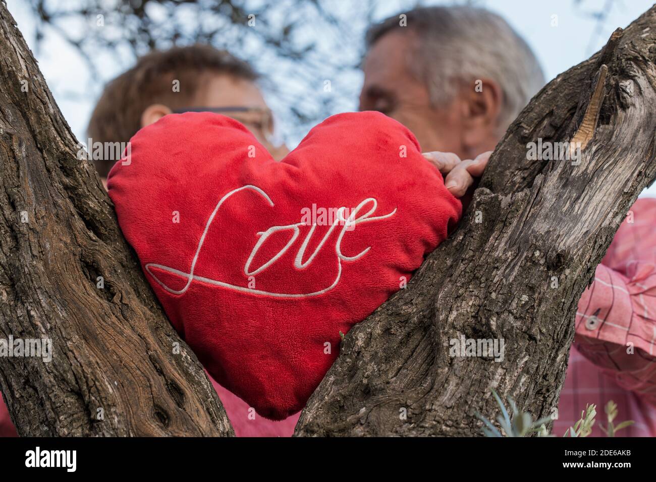 A happy old man and a woman with a red heart and the word love each ...