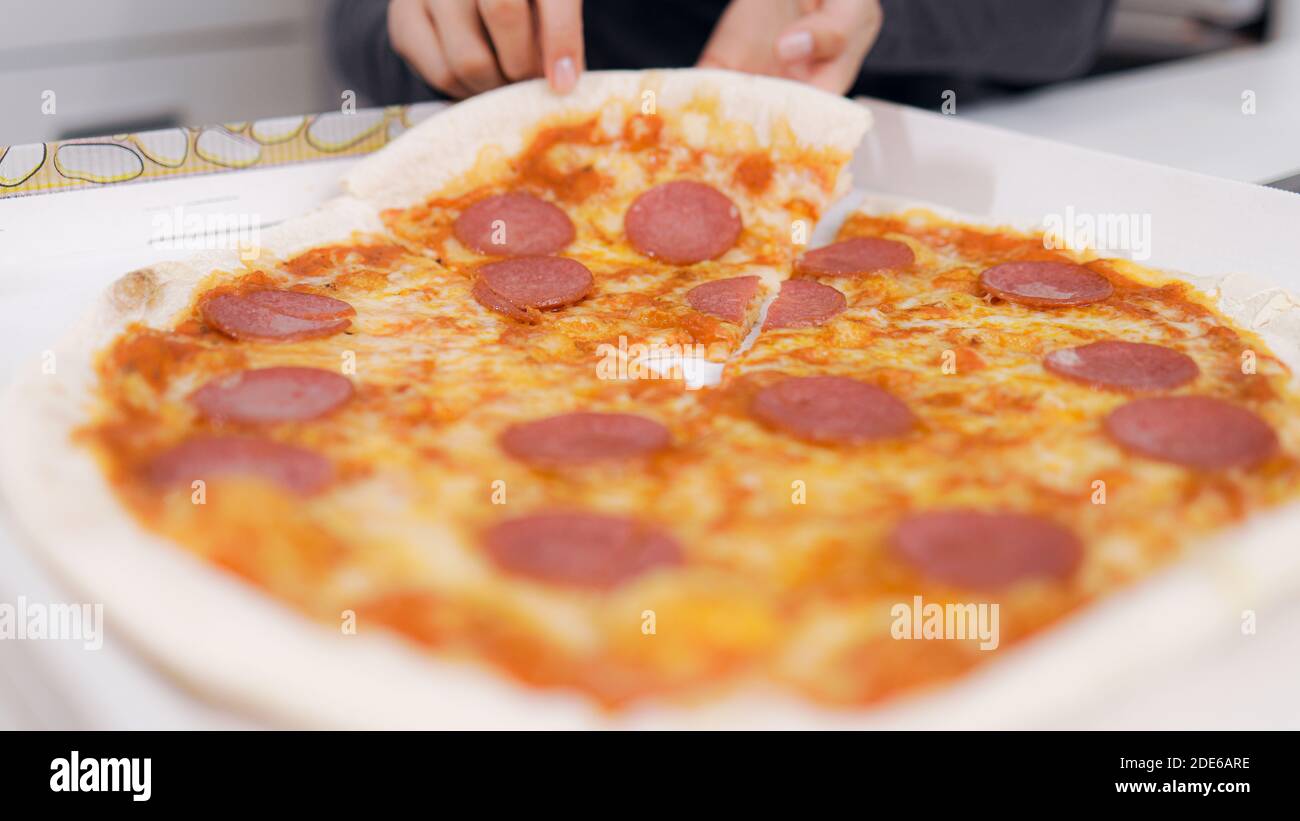 Grabbing a slice of pizza - close up shot Stock Photo - Alamy