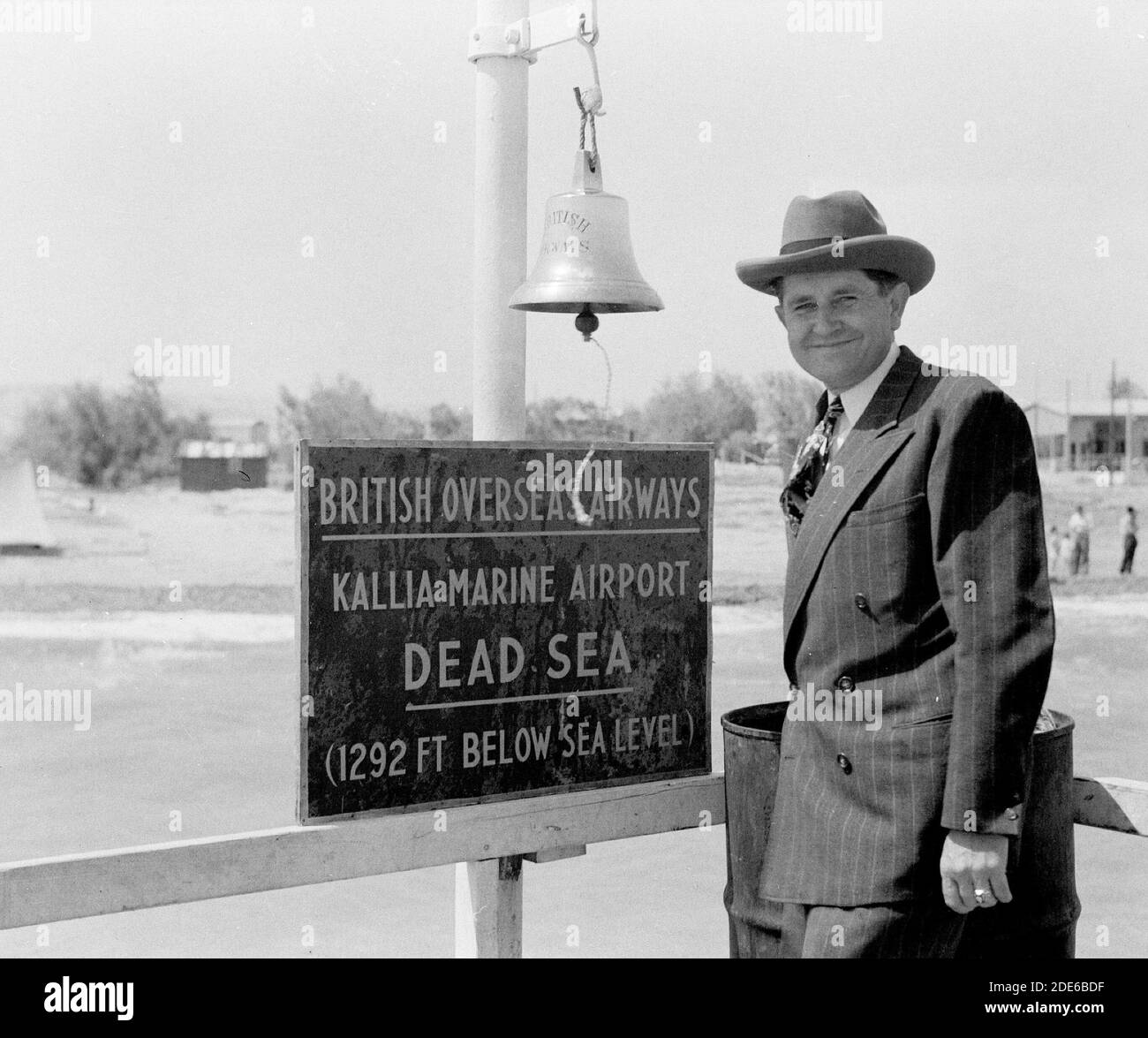 Man standing next to a sign for the Dead Sea Stock Photo - Alamy