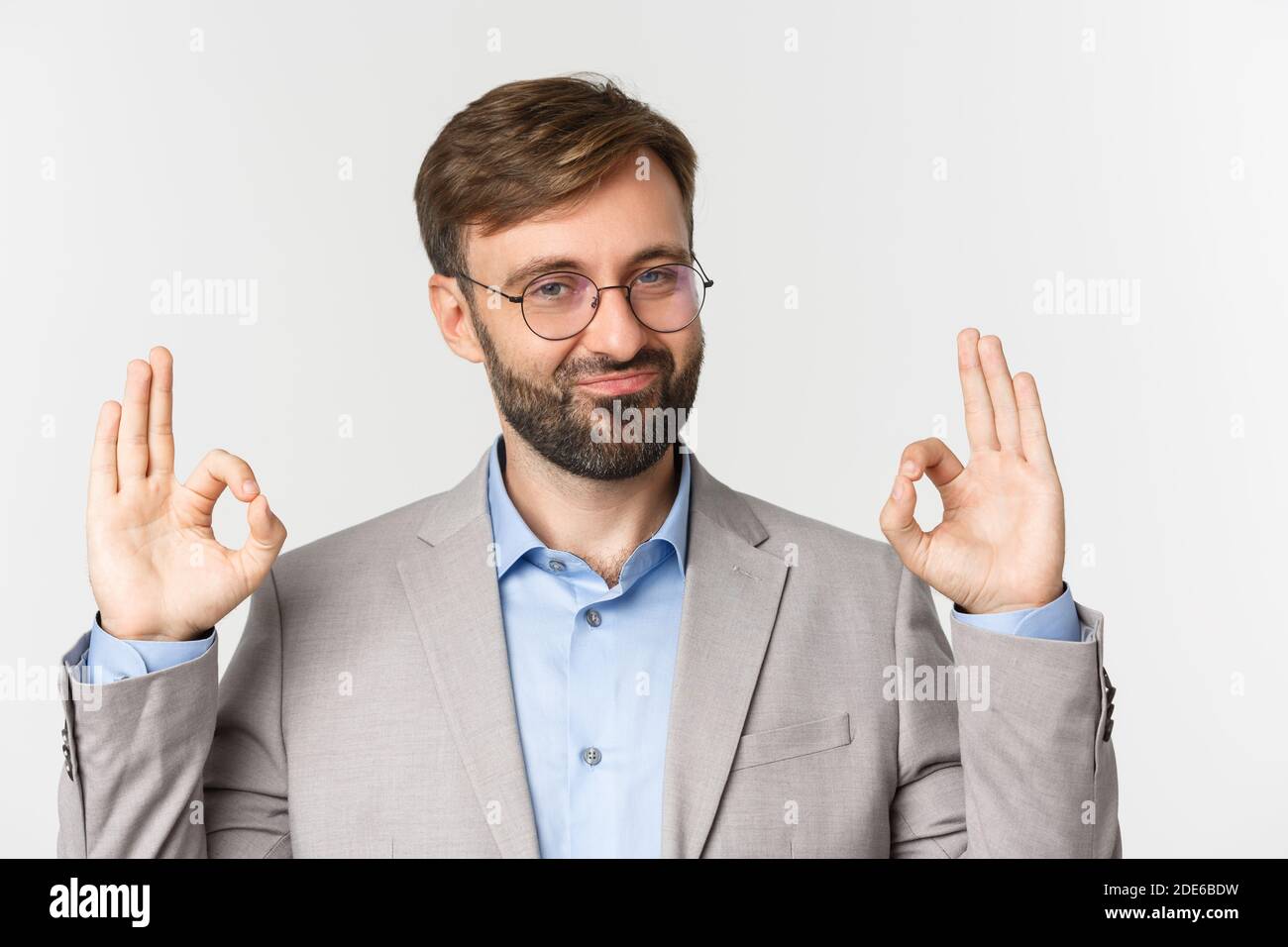 Close-up of impressed boss in gray suit and glasses, showing okay sign ...