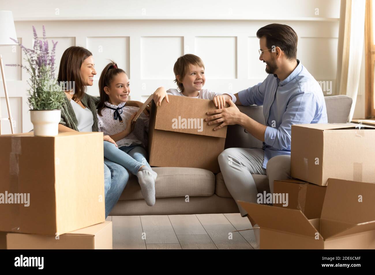Overjoyed family with kids have fun unpacking Stock Photo - Alamy