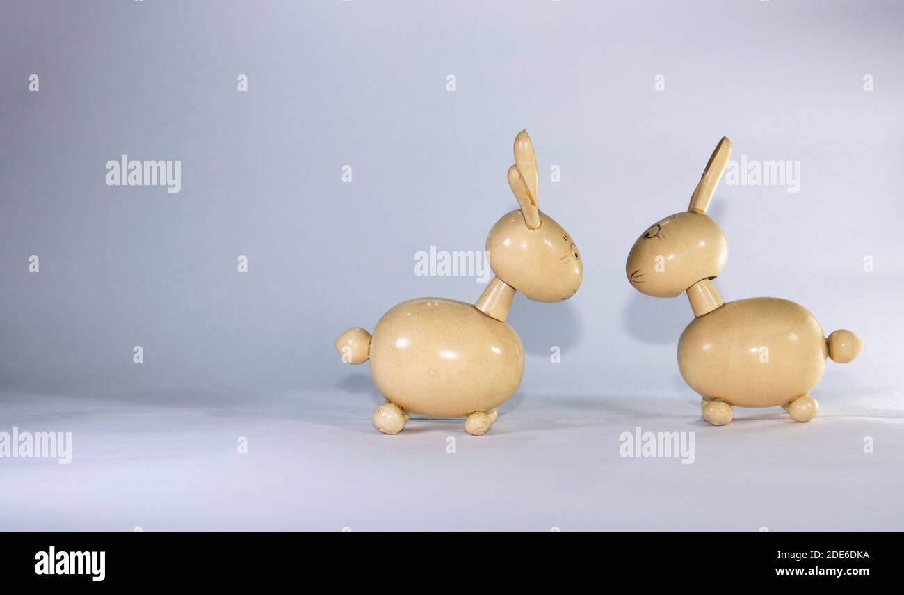 two wooden toy rabbits looking face to face Stock Photo - Alamy