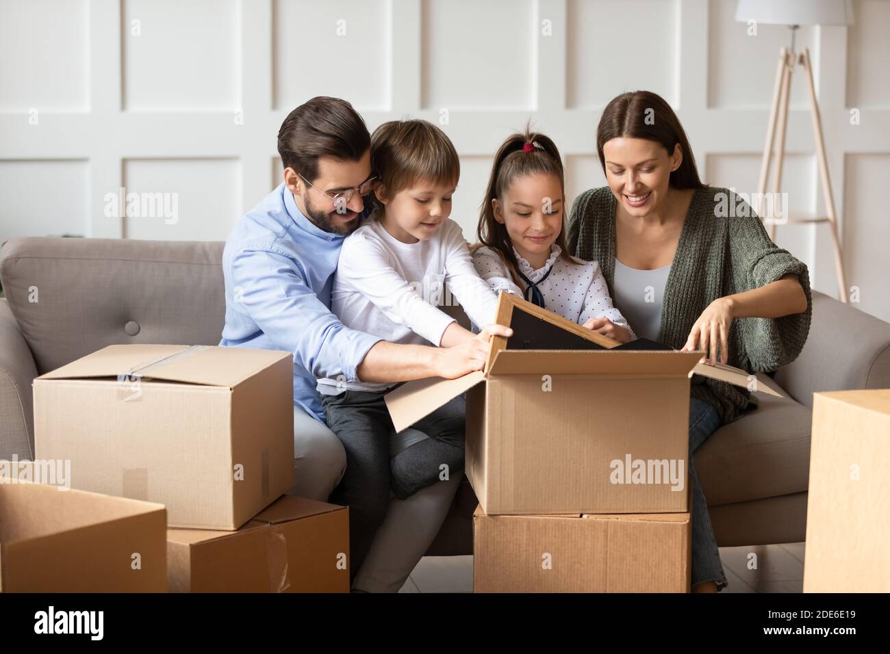 Excited family with children do unpacking in new home Stock Photo - Alamy
