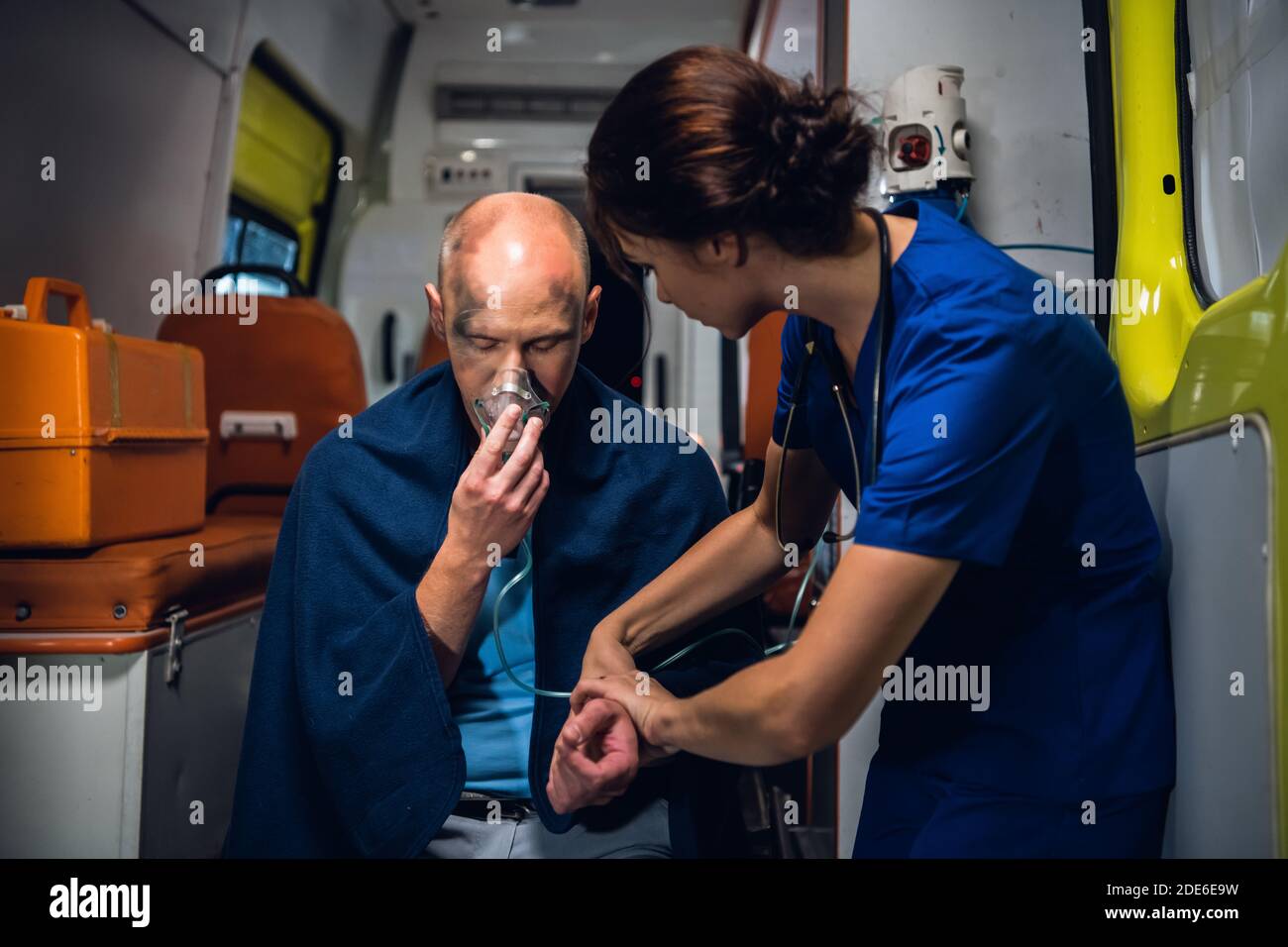 A female paramedic checking her patient's pulse, the patient is having ...