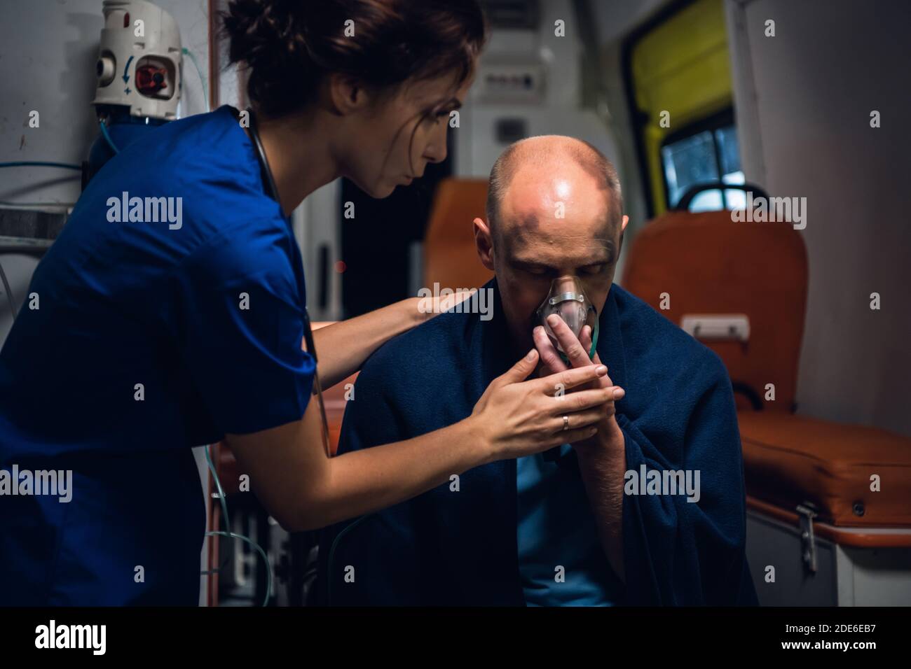 Paramedic presses an oxygen mask to a man's face, who got into an ...
