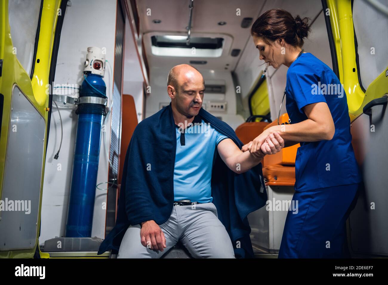 A young medical worker checking the traumatized hand of her patient in ...